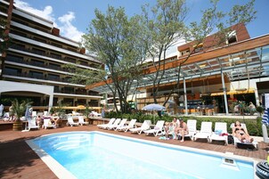 Uma área de piscina com espreguiçadeiras e um espaço para refeições.