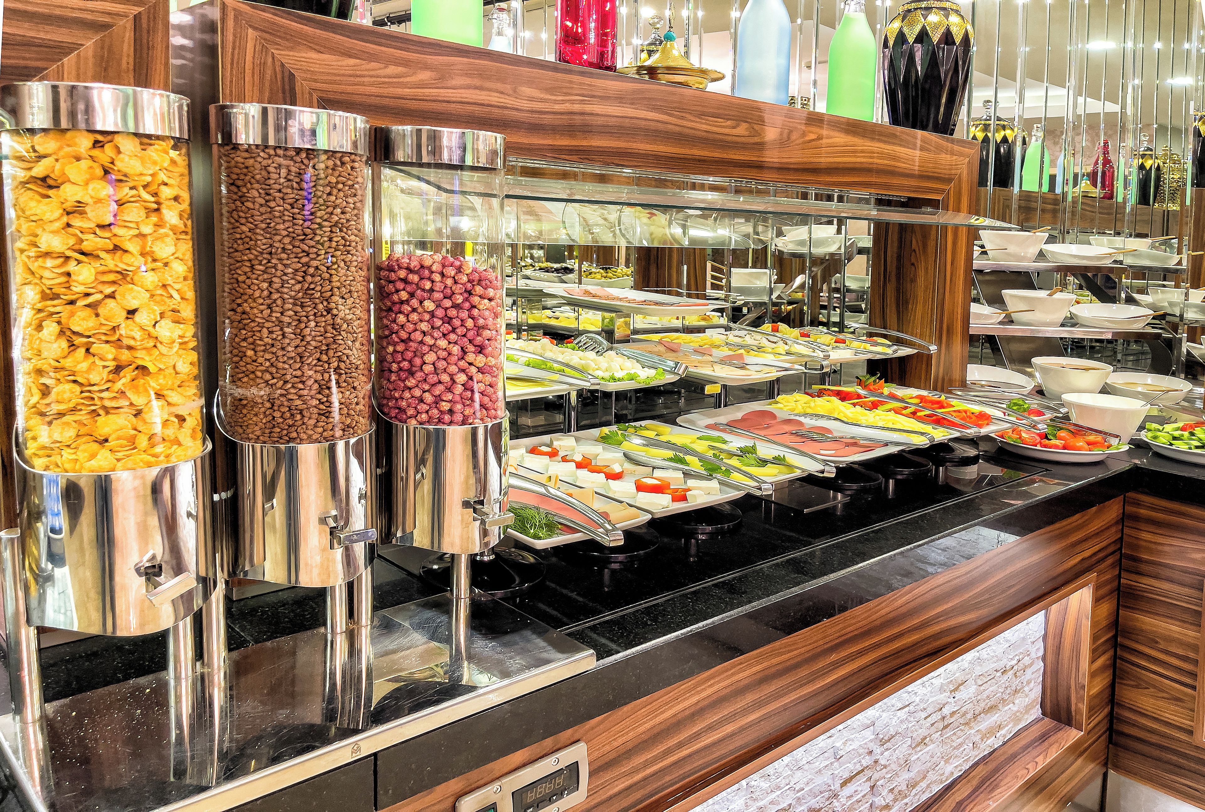 Buffet com diversos alimentos e recipientes.