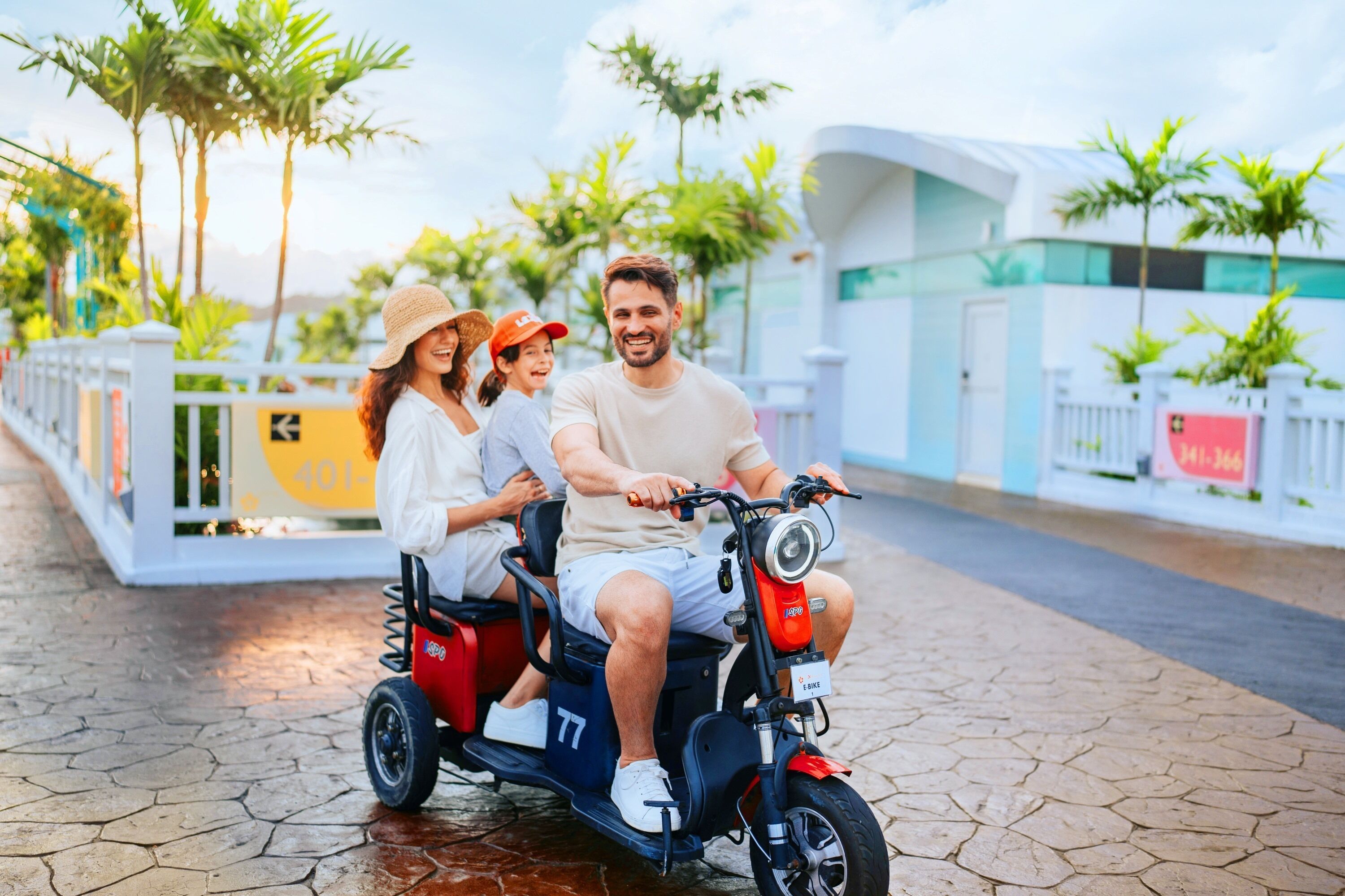 Uma família em uma scooter elétrica para três pessoas.