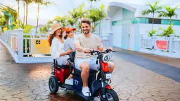 Uma família em uma scooter elétrica para três pessoas.