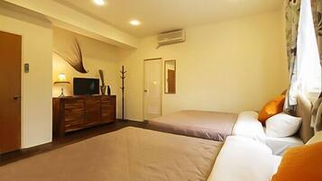 Quarto de hotel com duas camas, uma cômoda, uma televisão e um espelho.