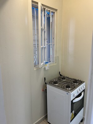 Um frigorífico, um micro-ondas, um forno, utensílios de cozinha 
