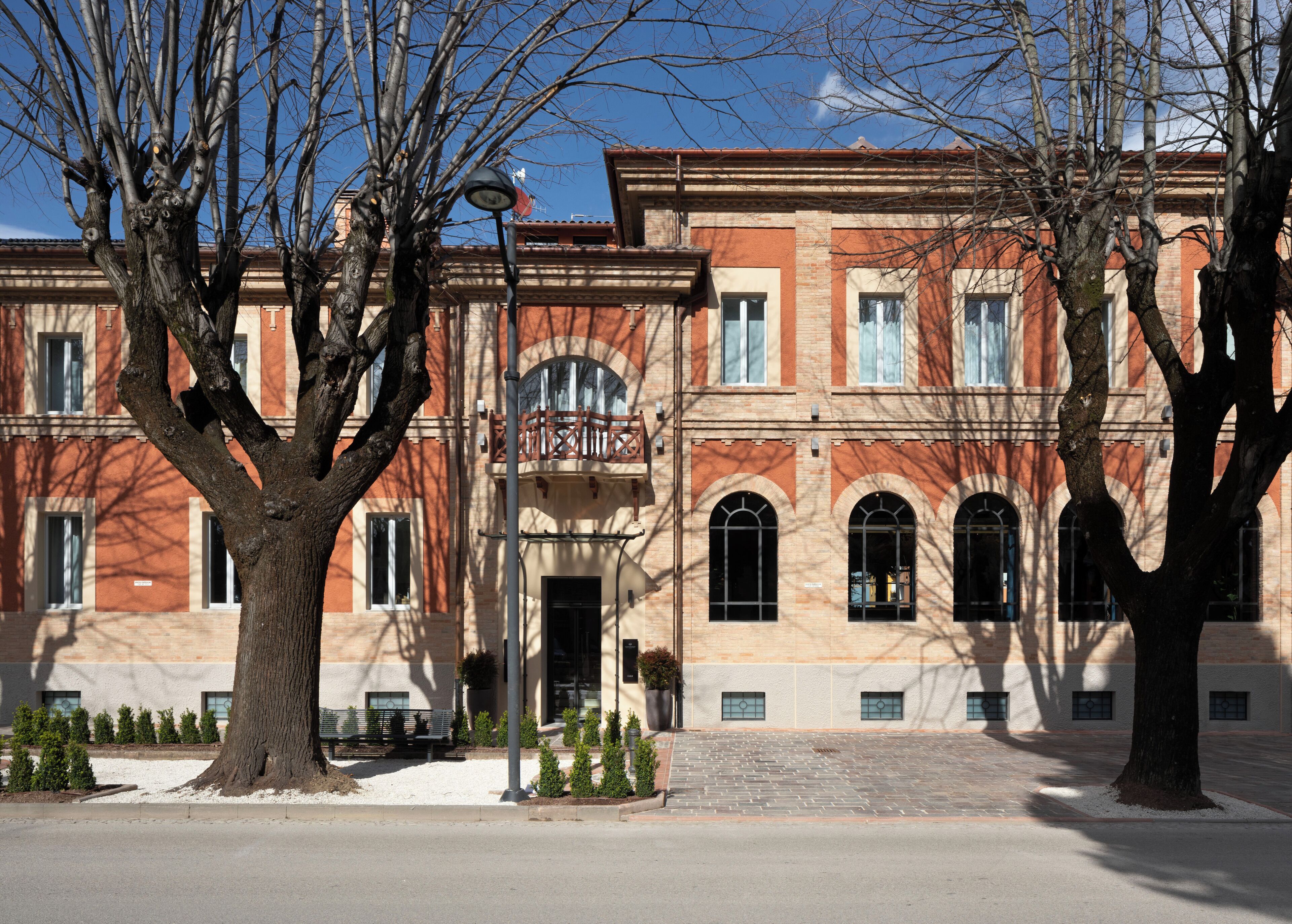 Um edifício com fachada simétrica, janelas em arco e varanda.