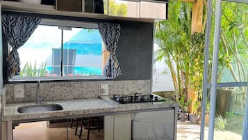 Loft Jardim - Recanto Revoar Campeche - Florianópolis | Cozinha privada | Um frigorífico, um micro-ondas, utensílios de cozinha, mesas de jantar