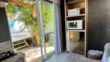 Loft Jardim - Recanto Revoar Campeche - Florianópolis | Cozinha privada | Um frigorífico, um micro-ondas, utensílios de cozinha, mesas de jantar