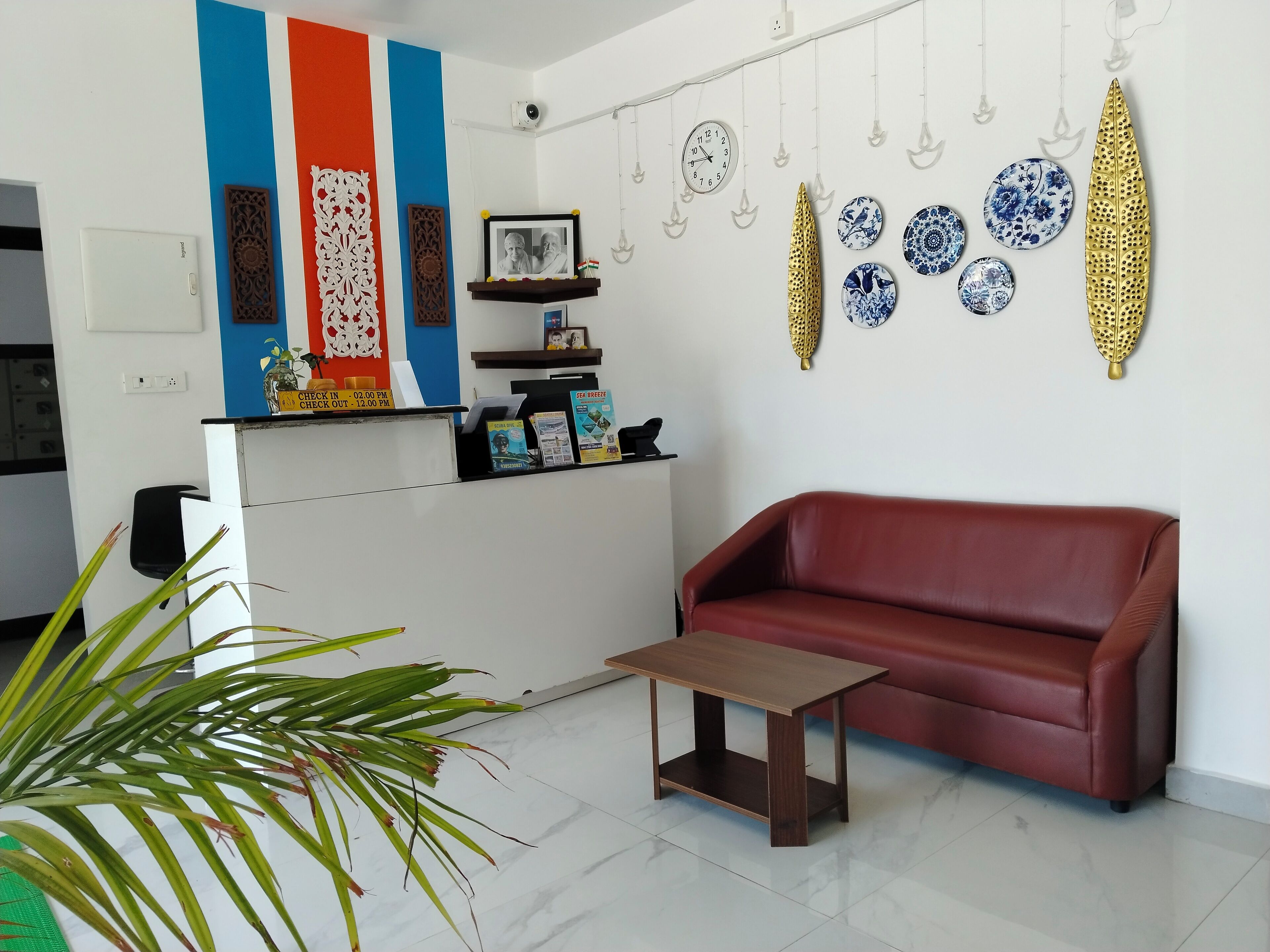 Uma sala de estar moderna com um sofá vermelho, uma mesa de madeira pequena e uma planta em vaso.
