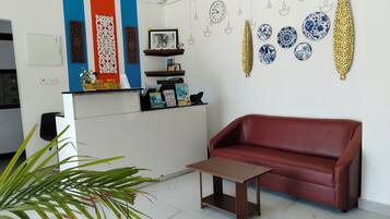 Uma sala de estar moderna com um sofá vermelho, uma mesa de madeira pequena e uma planta em vaso.