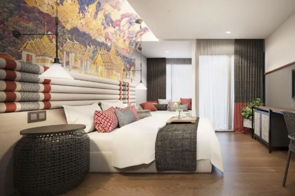 Quarto moderno com uma cama grande, uma escrivaninha e uma cadeira.
