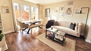 Uma sala de estar com sofá, mesa de centro e mesa de jantar.