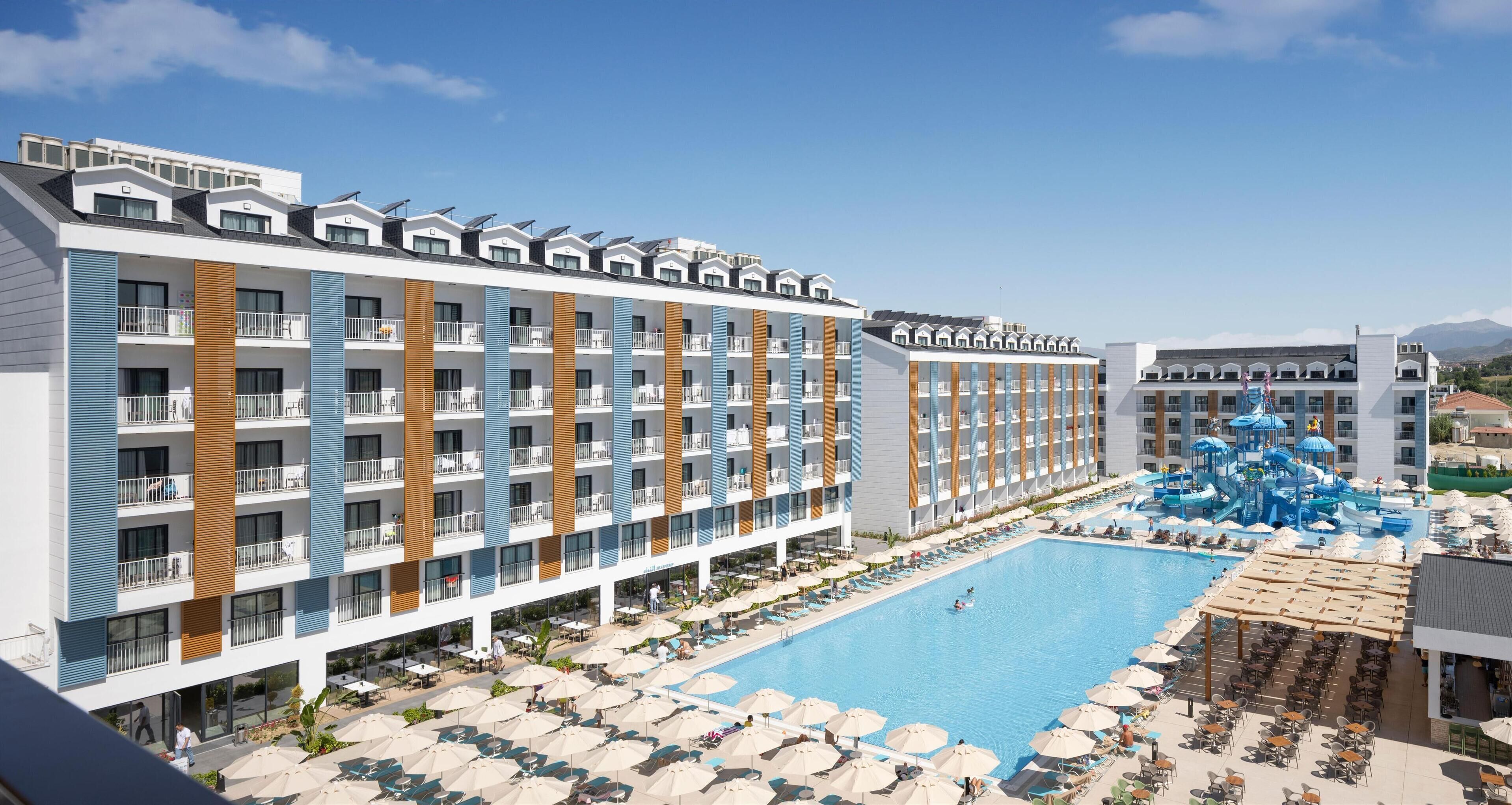 Hotel com várias varandas, piscina e área de parque aquático.