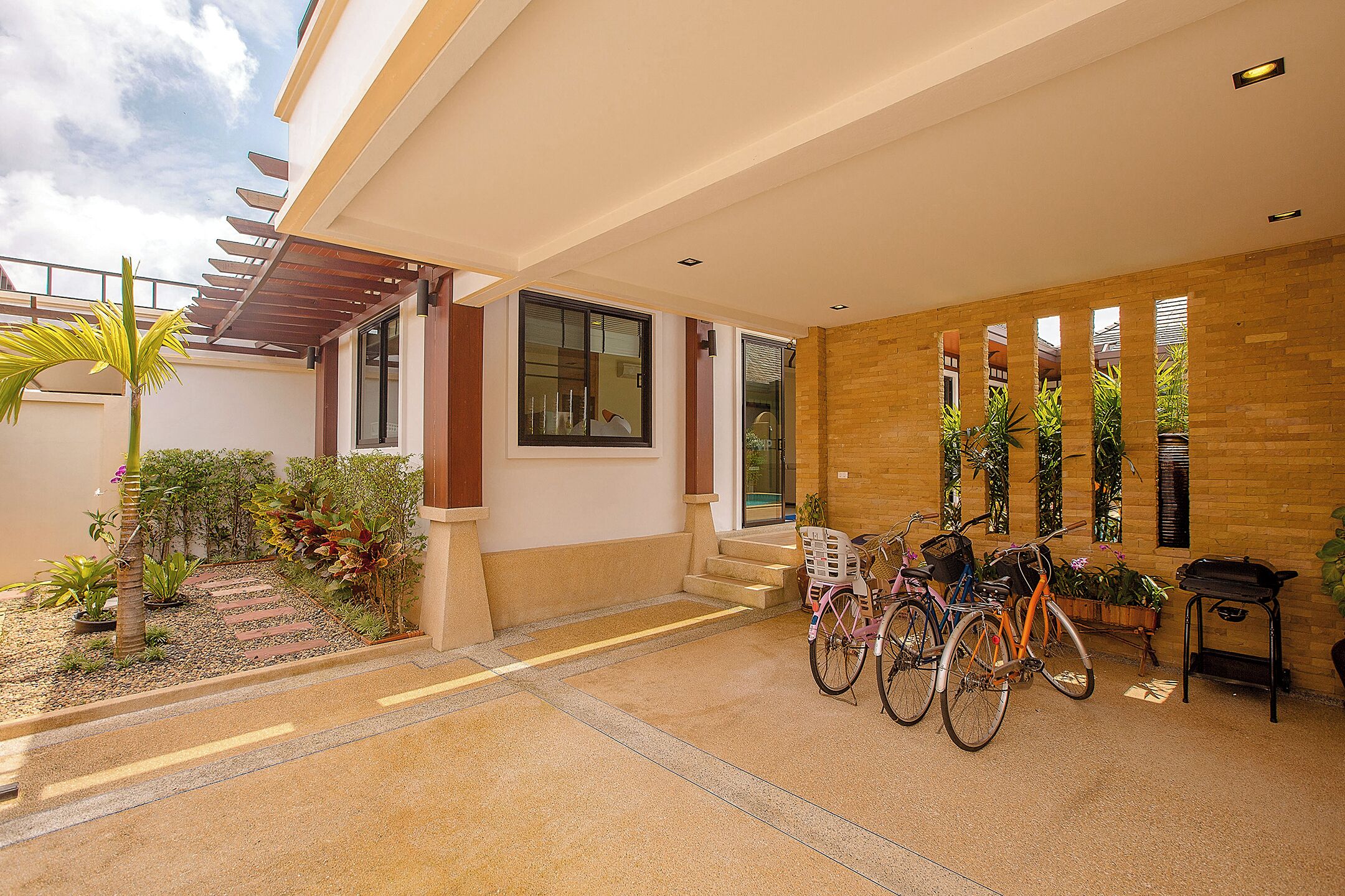 Um edifício moderno com entrada coberta, escadas e bicicletas estacionadas na frente.