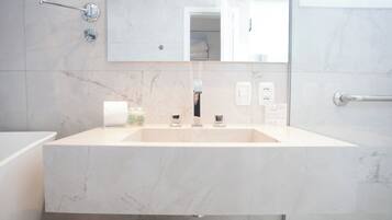 Uma casa de banho moderna com uma grande pia, um espelho e uma área de duche.