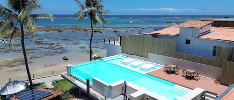 Piscina no terraço com vista para a praia e o oceano.