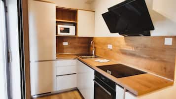 Apartamento Deluxe | Cozinha privada | Um frigorífico/congelador grande, um micro-ondas, uma placa de cozinha