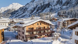 Uma cidade montanhosa coberta de neve com um edifício notável identificado como "Rogail".