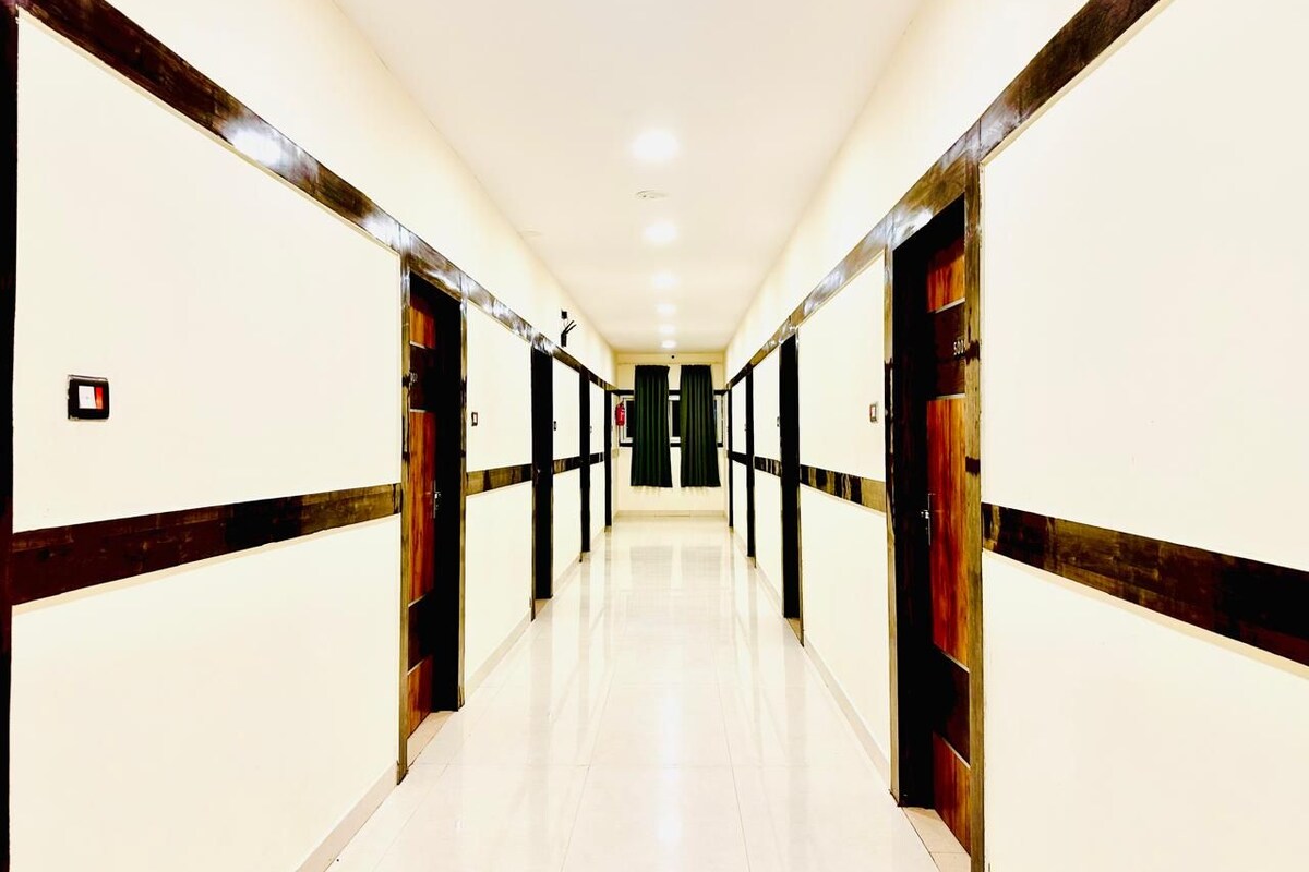 Um corredor comprido e estreito, com portas em ambos os lados, que dá para um quarto no final.