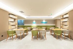 Uma biblioteca moderna com fileiras de mesas e cadeiras, estantes de livros e um teto com iluminação embutida.