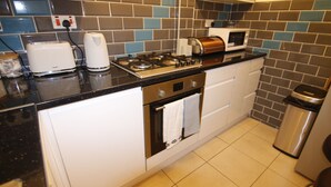 Uma cozinha equipada com fogão a gás, forno, micro-ondas e torradeira.