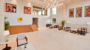 Um hall amplo com teto alto, mobiliário moderno e obras de arte nas paredes.