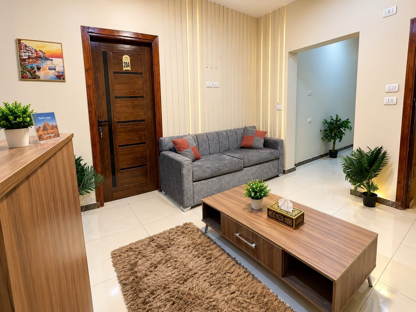 Uma sala de estar moderna com um sofá cinzento, um aparador de madeira e uma mesa de centro.