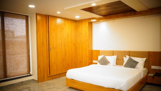 Quarto moderno com estrutura de cama de madeira, um guarda-roupa amplo e teto com iluminação embutida.