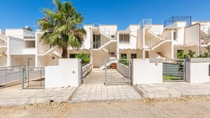 Um edifício residencial moderno com várias varandas e uma escadaria central.
