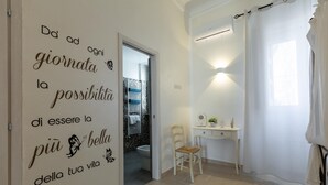 Um banheiro com cortina de chuveiro, pia e uma cadeira.