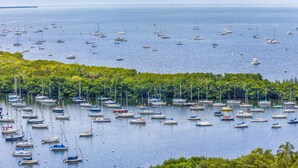 Uma marina com vários barcos atracados, rodeada por vegetação exuberante.