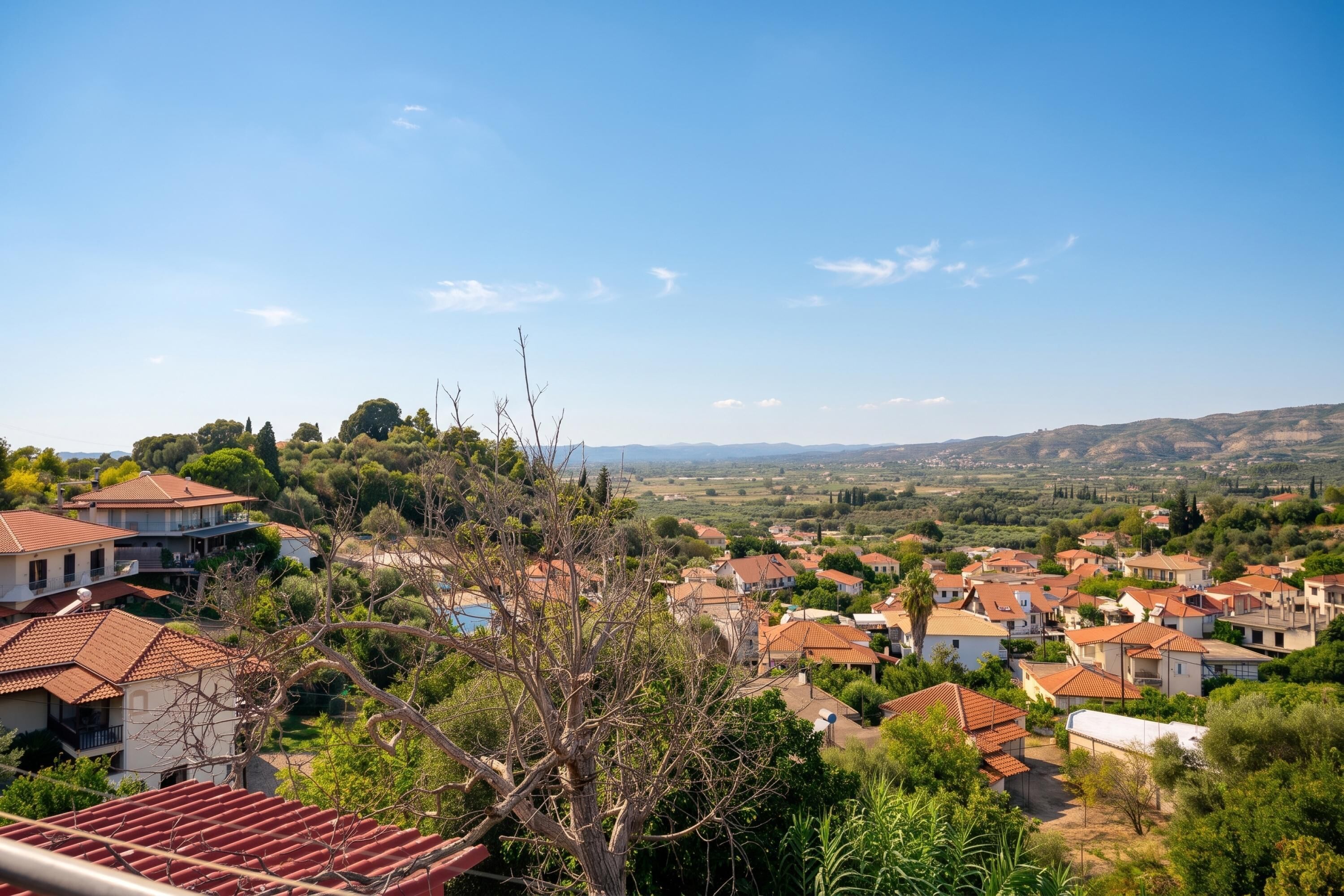 Área residencial com casas, árvores e céu claro.