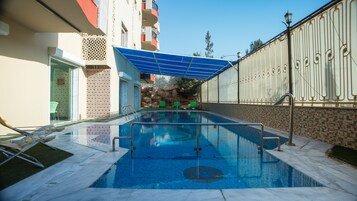 Piscina interior, guarda-sóis, nadadores-salvadores no local 