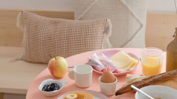 Uma mesa de café da manhã com panquecas, ovos, suco e uma garrafa de leite.