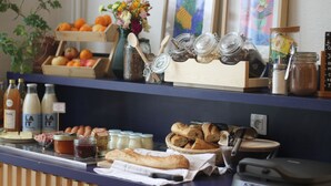 Um balcão de café da manhã com frutas, pão e acompanhamentos.