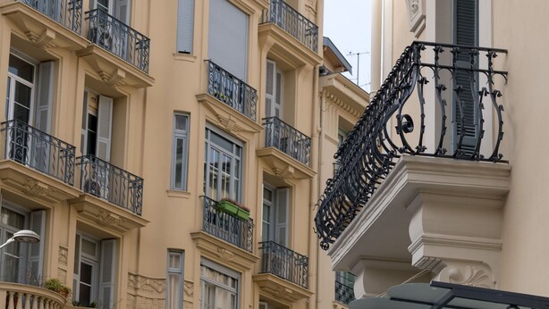 Um edifício de vários andares com varandas ornamentadas e estilo arquitetônico clássico.