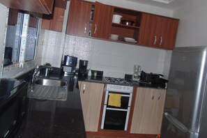 Um frigorífico, um micro-ondas, um forno, uma placa de cozinha 