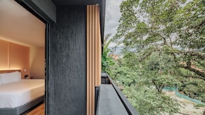 Quarto moderno com uma cama, uma parede escura com textura e vista para um jardim exuberante.