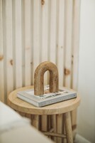 Uma cadeira de madeira com encosto curvo e um livro intitulado 'MADE for LIVING' sobre ela.