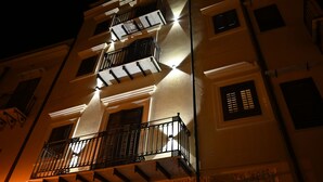 Um edifício com várias andares, varandas, uma placa e um poste de luz.