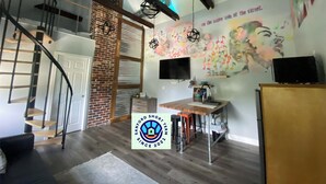 Um interior moderno com escada, parede de tijolos, mural e área de trabalho.