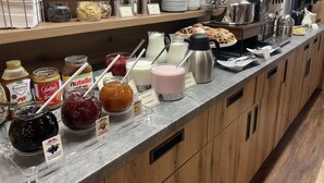 Um balcão de buffet com diversos alimentos e acompanhamentos.