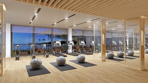 Academia moderna com equipamentos de ginástica, janelas amplas e teto de madeira.