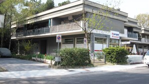Um edifício de dois andares com varanda, placa de proibido estacionar e fachada com um anúncio para 'europa discount'.