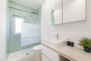 Apartamento | Casa de banho | Um polibã e uma banheira separados, um secador de cabelo 