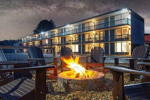 Um hotel com várias varandas, área de estar ao ar livre e lareira.