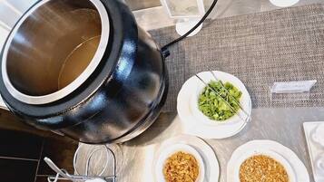 Uma área de cozinha com uma panela preta grande, dois recipientes com legumes picados e dois recipientes com granola.