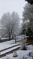 Paisagem coberta de neve com uma estrutura de madeira e um caminho.