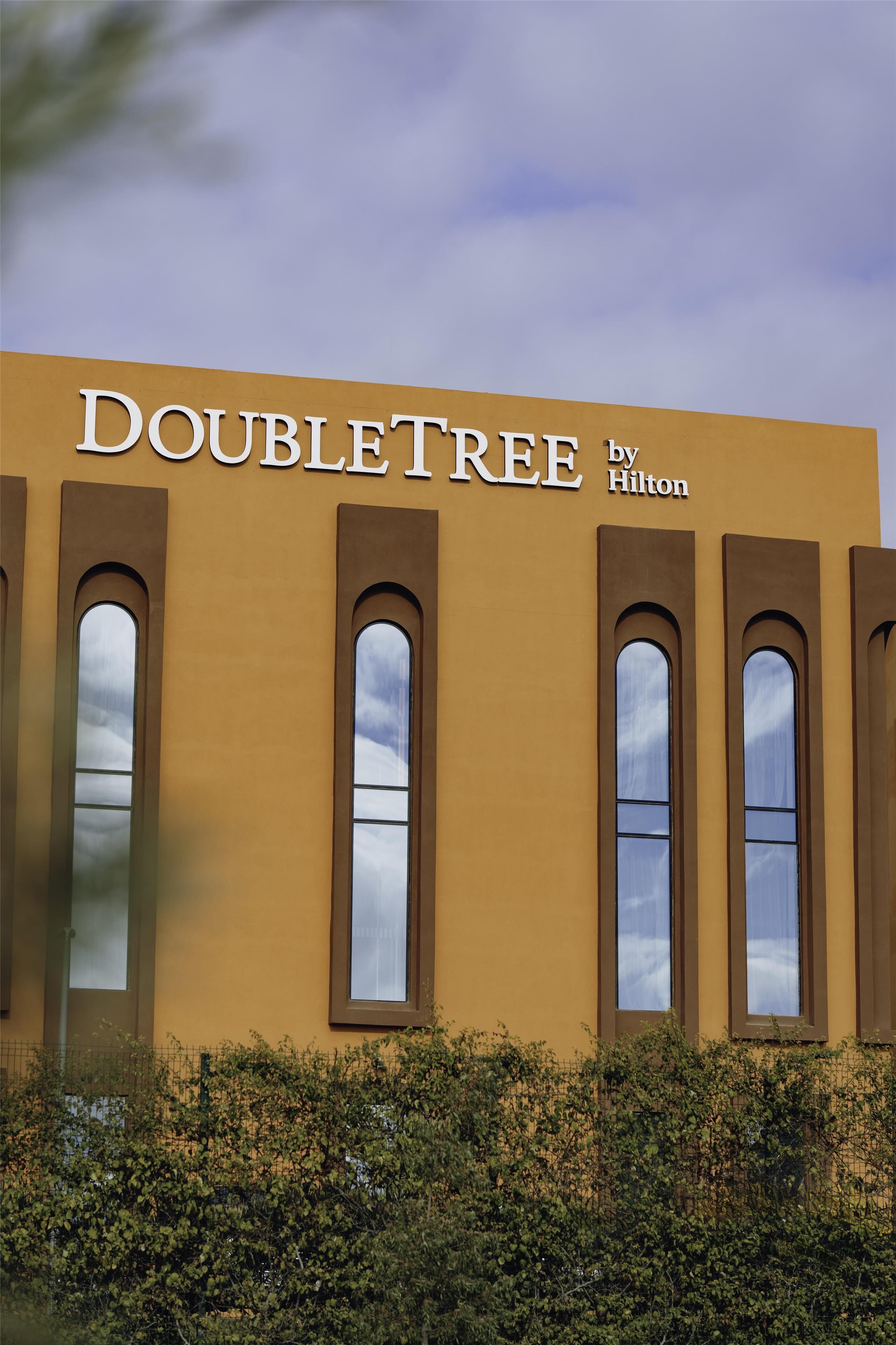 Um edifício com a fachada exibindo o nome "DOUBLETREE by Hilton".