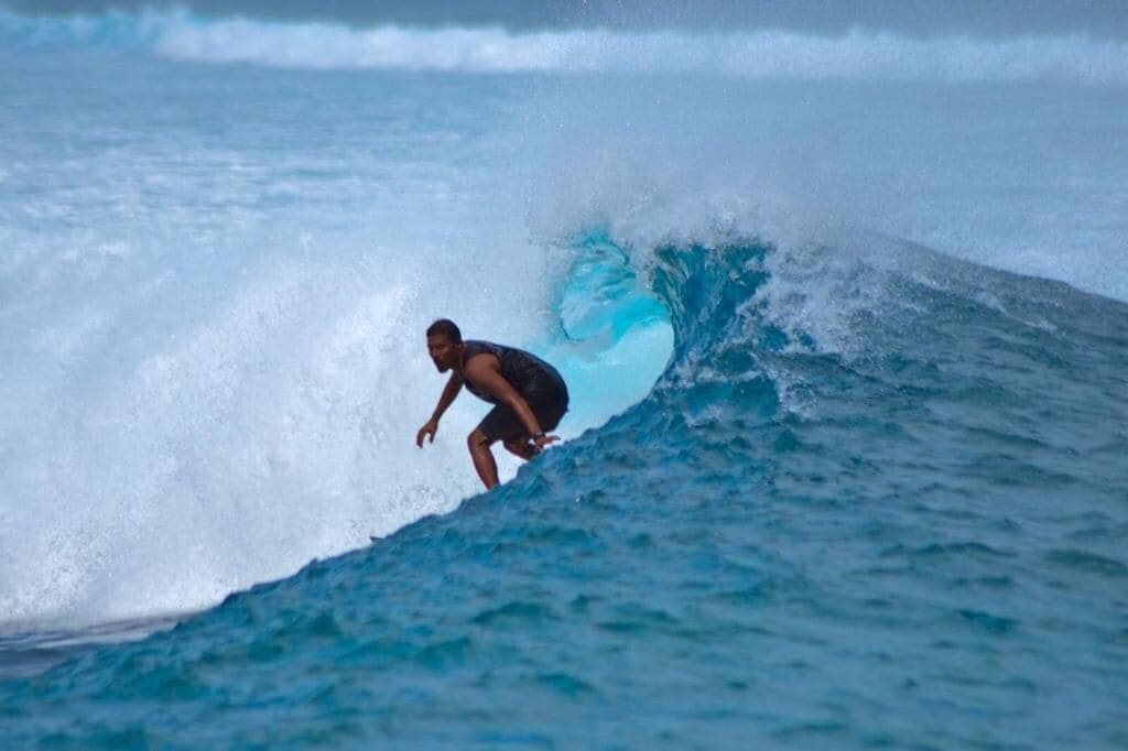 Uma pessoa surfando uma onda.
