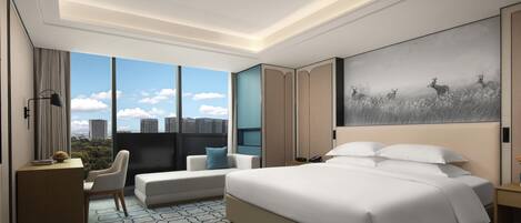 Quarto de hotel moderno com uma cama grande, área de estar, escrivaninha e vista para a cidade.