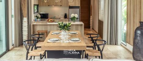 Uma cozinha moderna com armários de madeira, uma ilha central e luminárias pendentes.