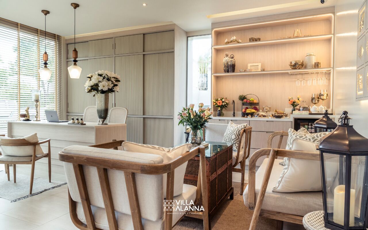 Uma sala de estar moderna com móveis de madeira, uma mesa de centro de vidro e uma área de cozinha com prateleiras embutidas.